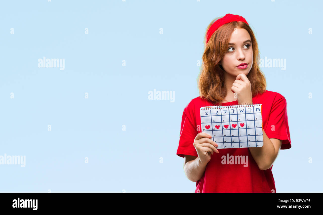 Young beautiful woman over isolated background holding menstruation ...