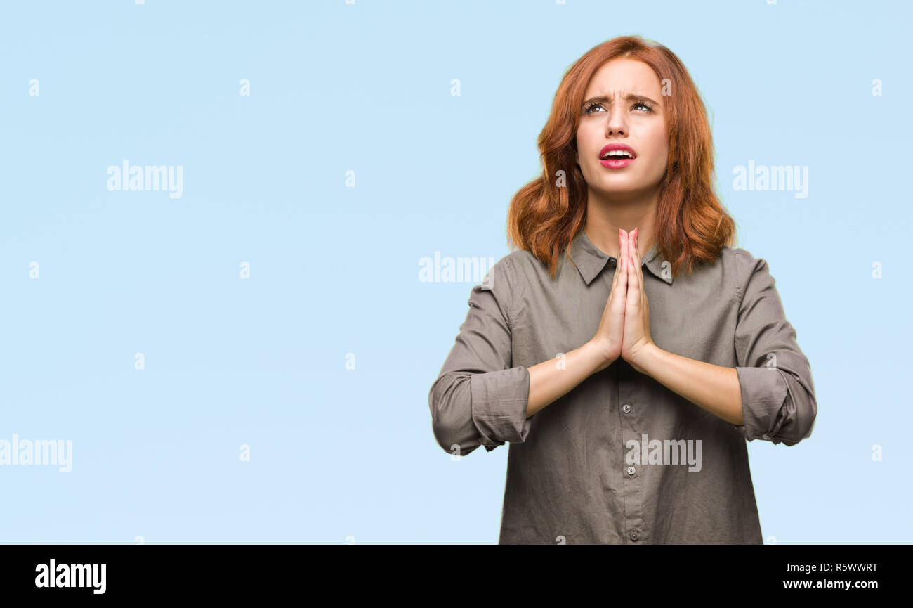 Young beautiful woman over isolated background begging and praying with ...