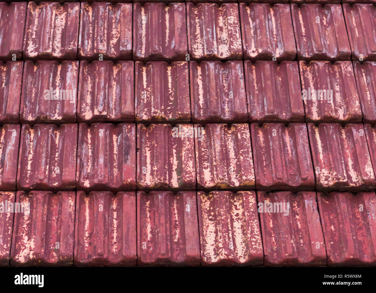 old and weathered red stone roof tiling in macro closeup with faded out ...