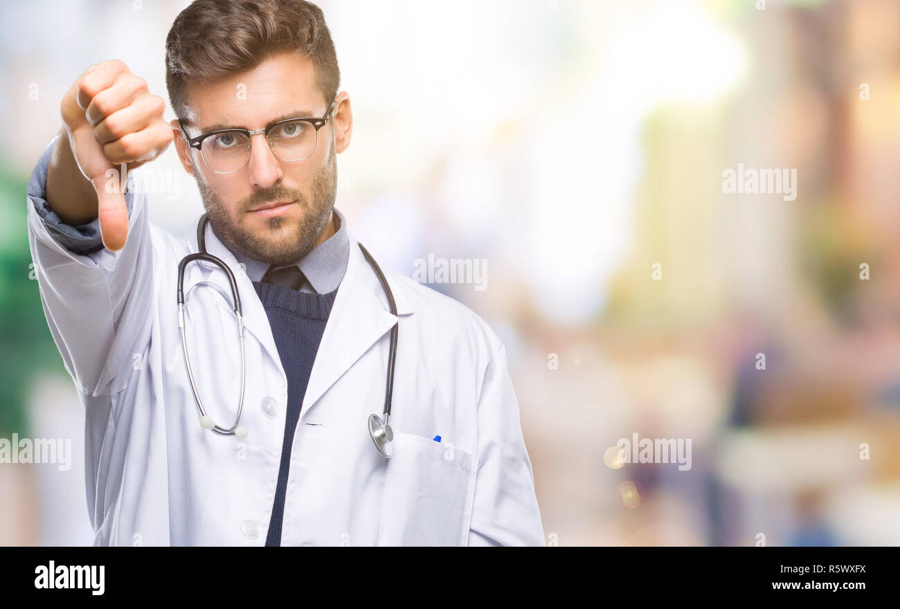 Young handsome doctor man over isolated background looking unhappy and ...