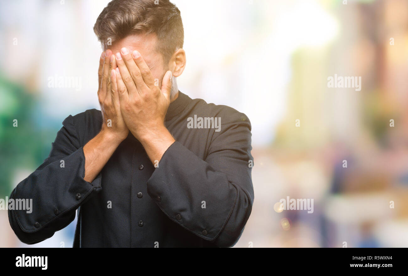 Young catholic christian priest man over isolated background with sad ...