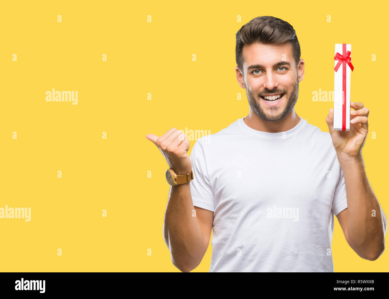 Young handsome man in love giving valentine present over isolated ...