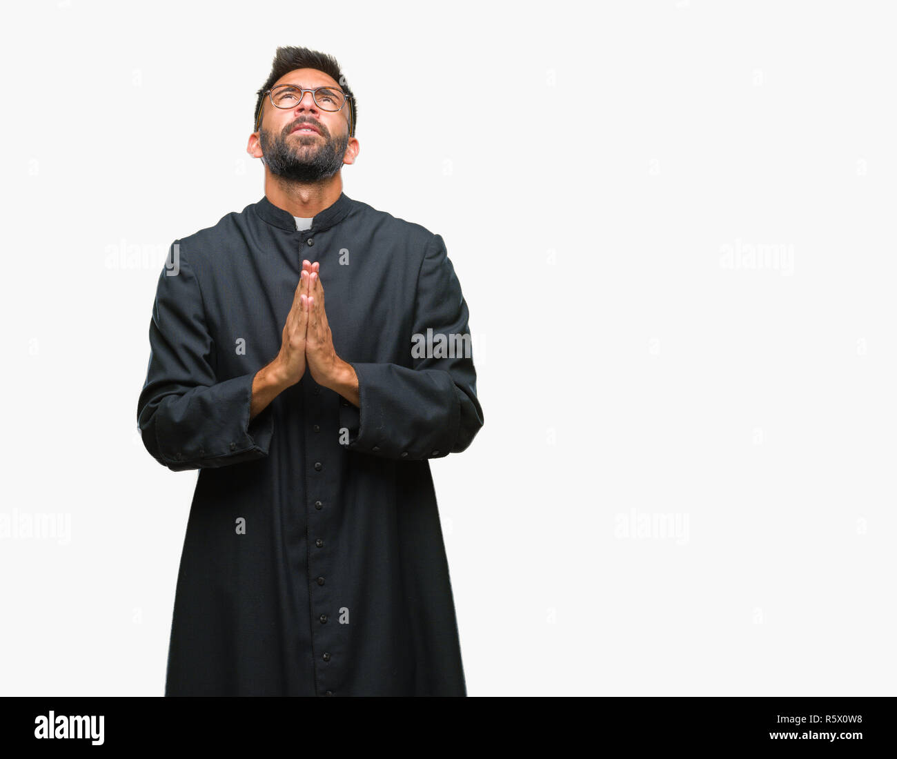Adult hispanic catholic priest man over isolated background begging and ...