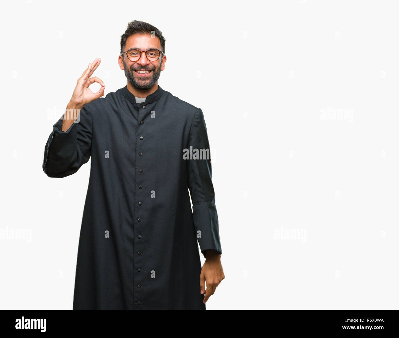 Adult hispanic catholic priest man over isolated background smiling ...
