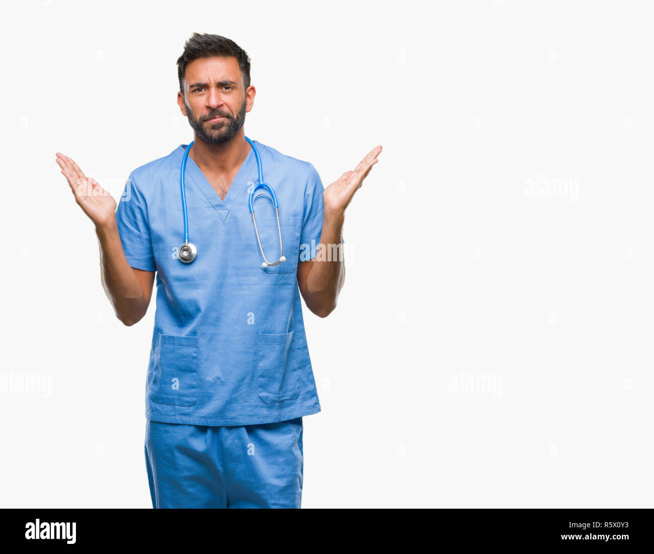 Adult hispanic doctor or surgeon man over isolated background clueless ...