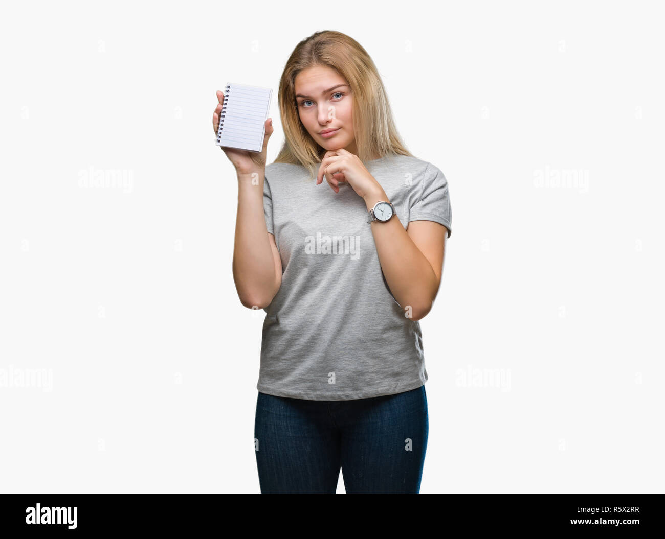 Young caucasian woman holding blank notebook over isolated background ...