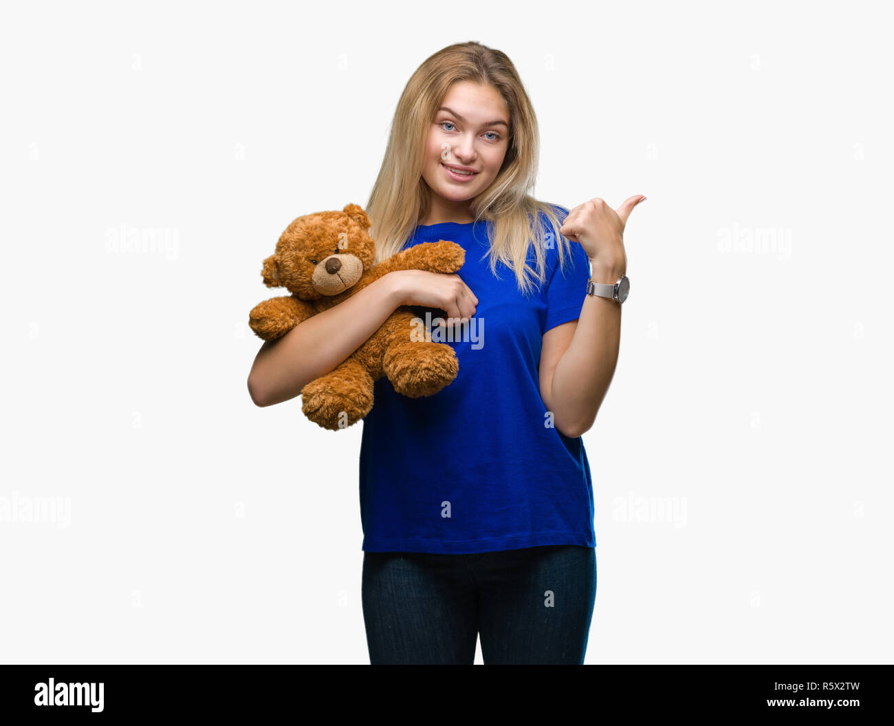 Young caucasian woman holding cute teddy bear over isolated background ...