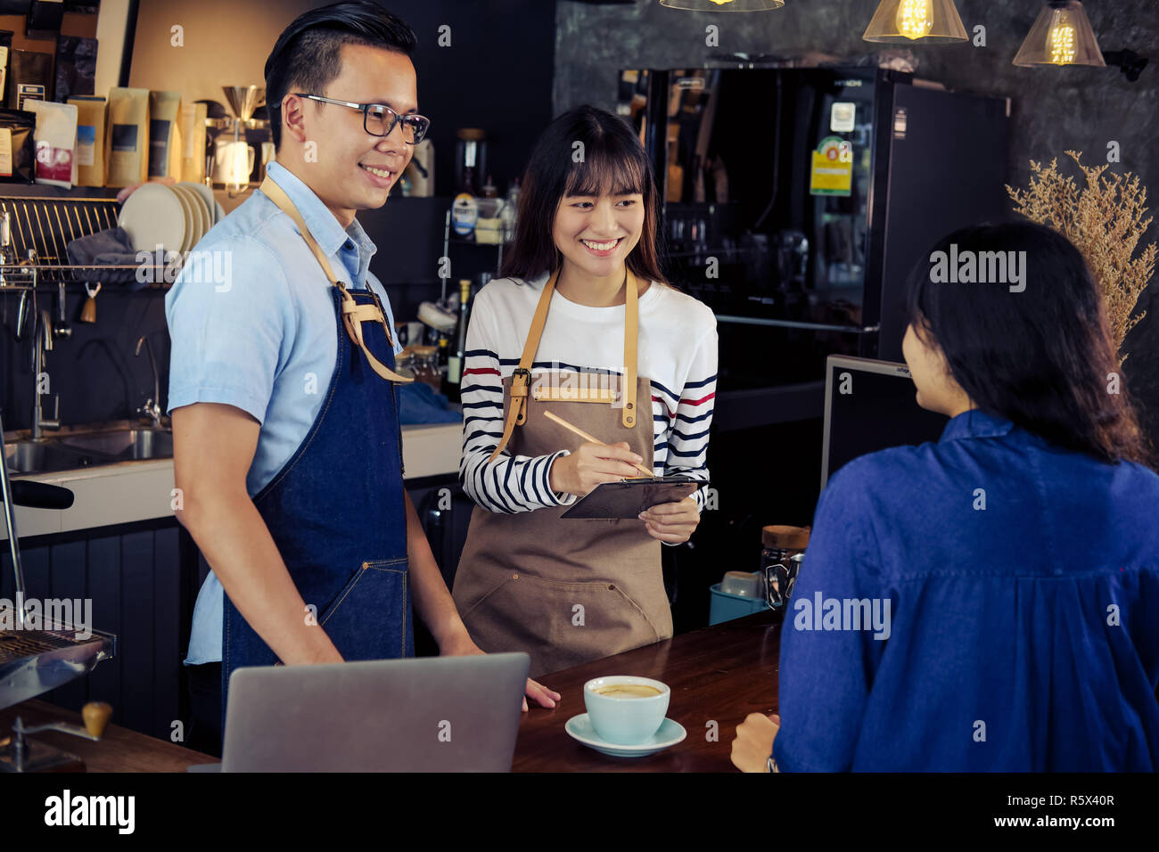 Young baristas ordering at counter bar in cafe. Cafe restaurant service ...