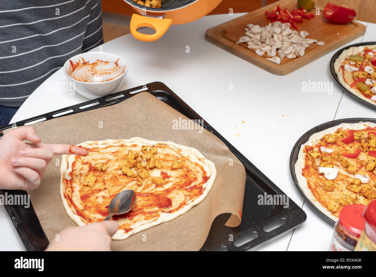 Preparation of a delicious pizza in a home kitchen. Laying and ...