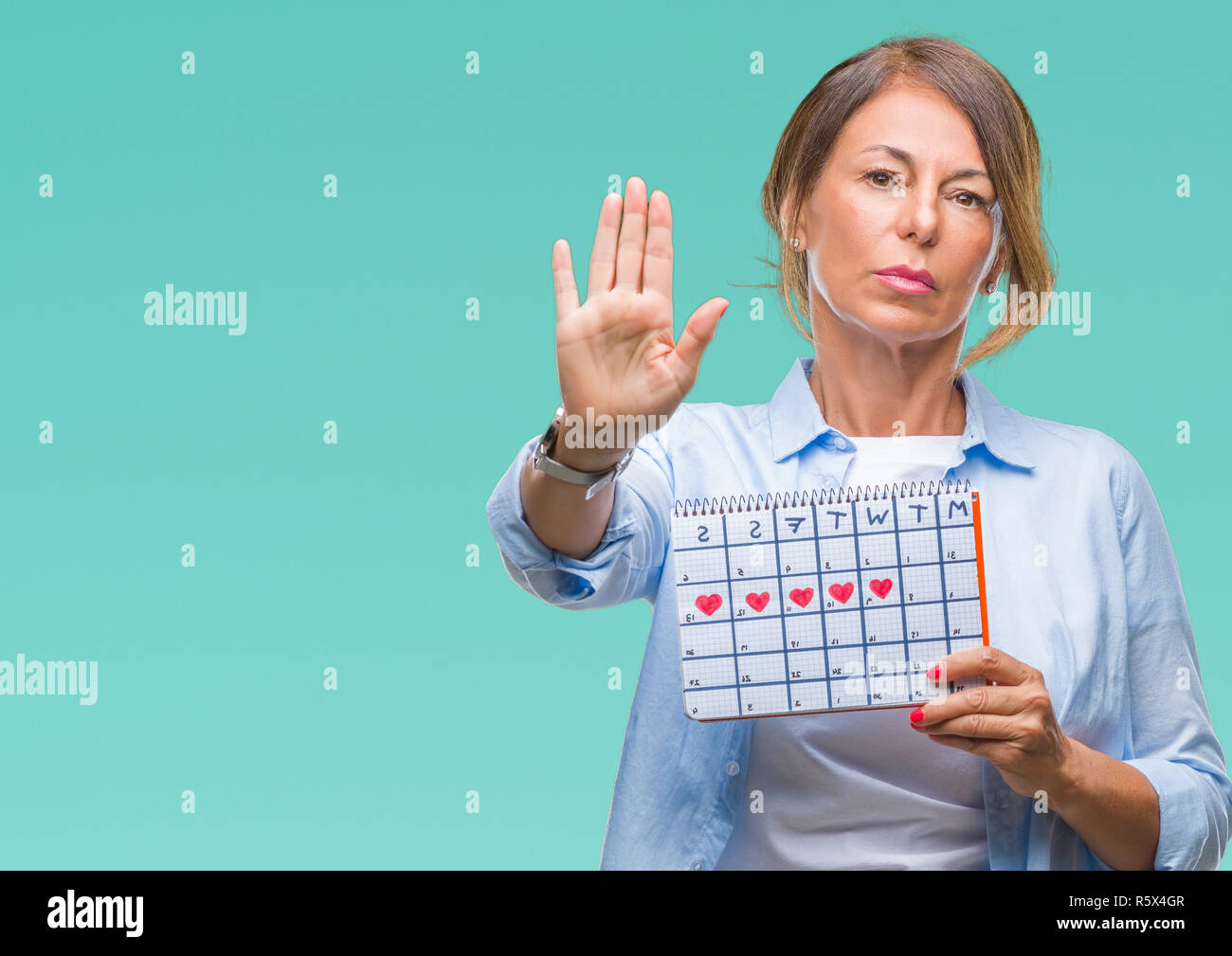 Middle age senior hispanic woman holding menstruation calendar over ...
