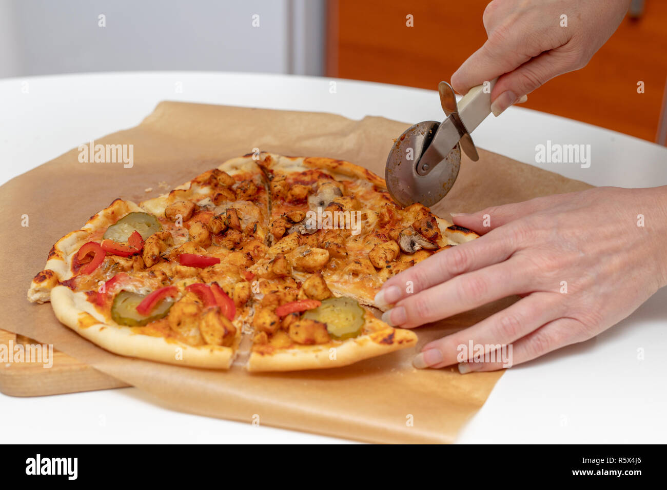 Baking a delicious pizza in a home kitchen. Slicing and stacking the ...