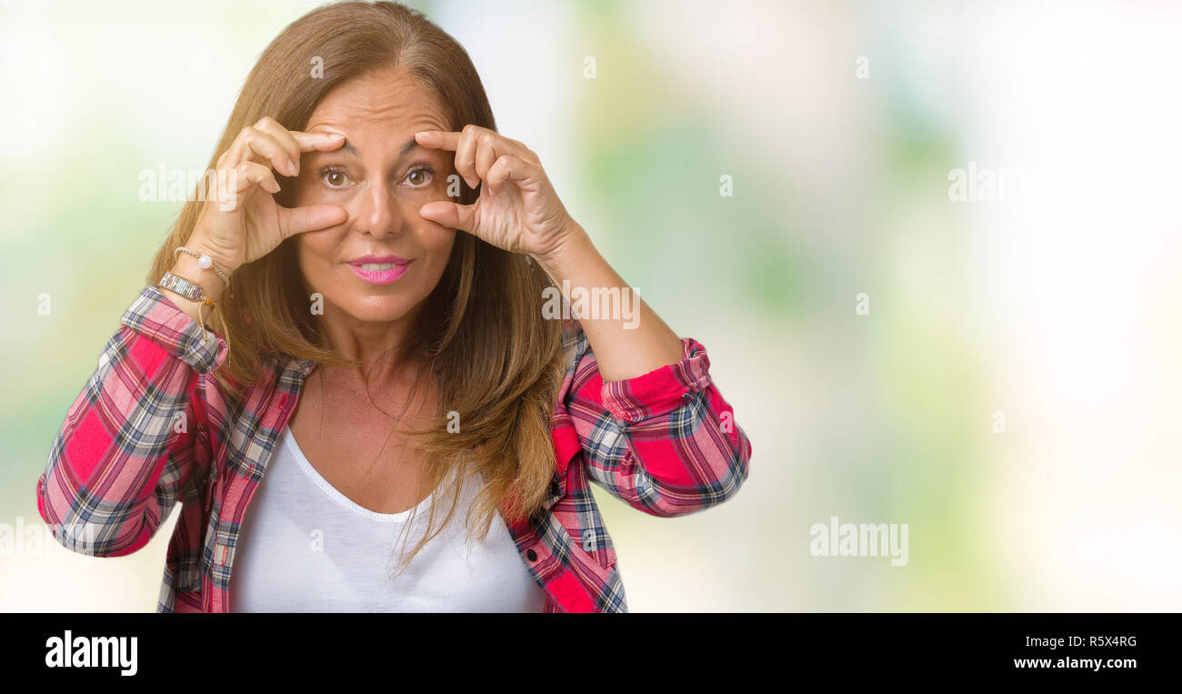 Beautiful middle age woman wearing over isolated background Trying to ...
