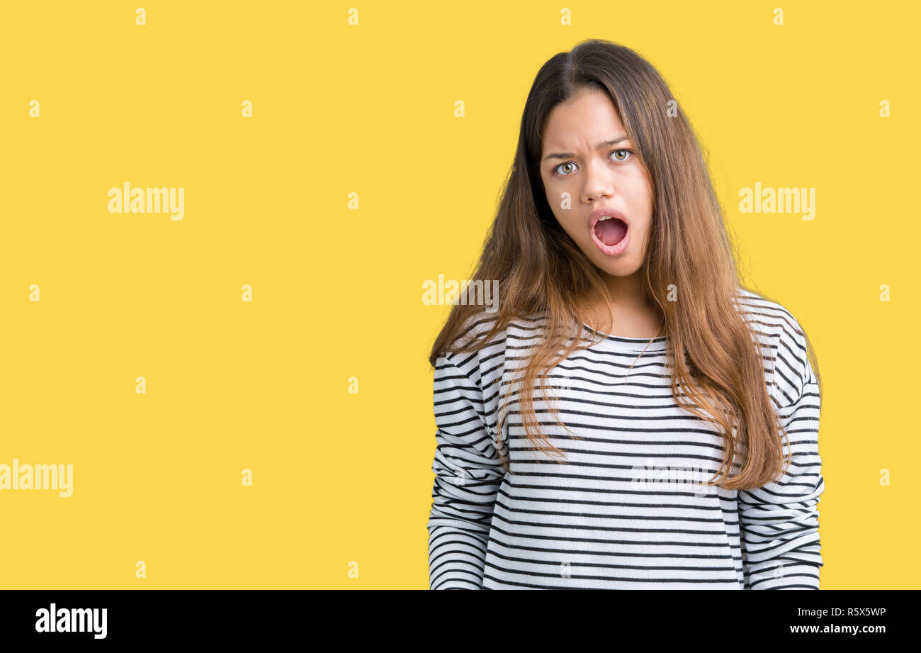 Young beautiful brunette woman wearing stripes sweater over isolated ...