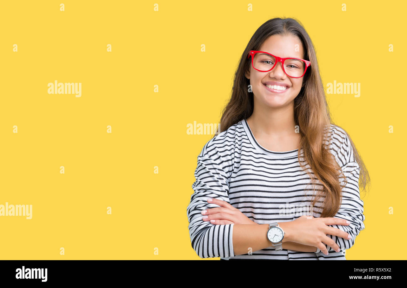 Young beautiful brunette woman wearing stripes sweater and red glasses ...