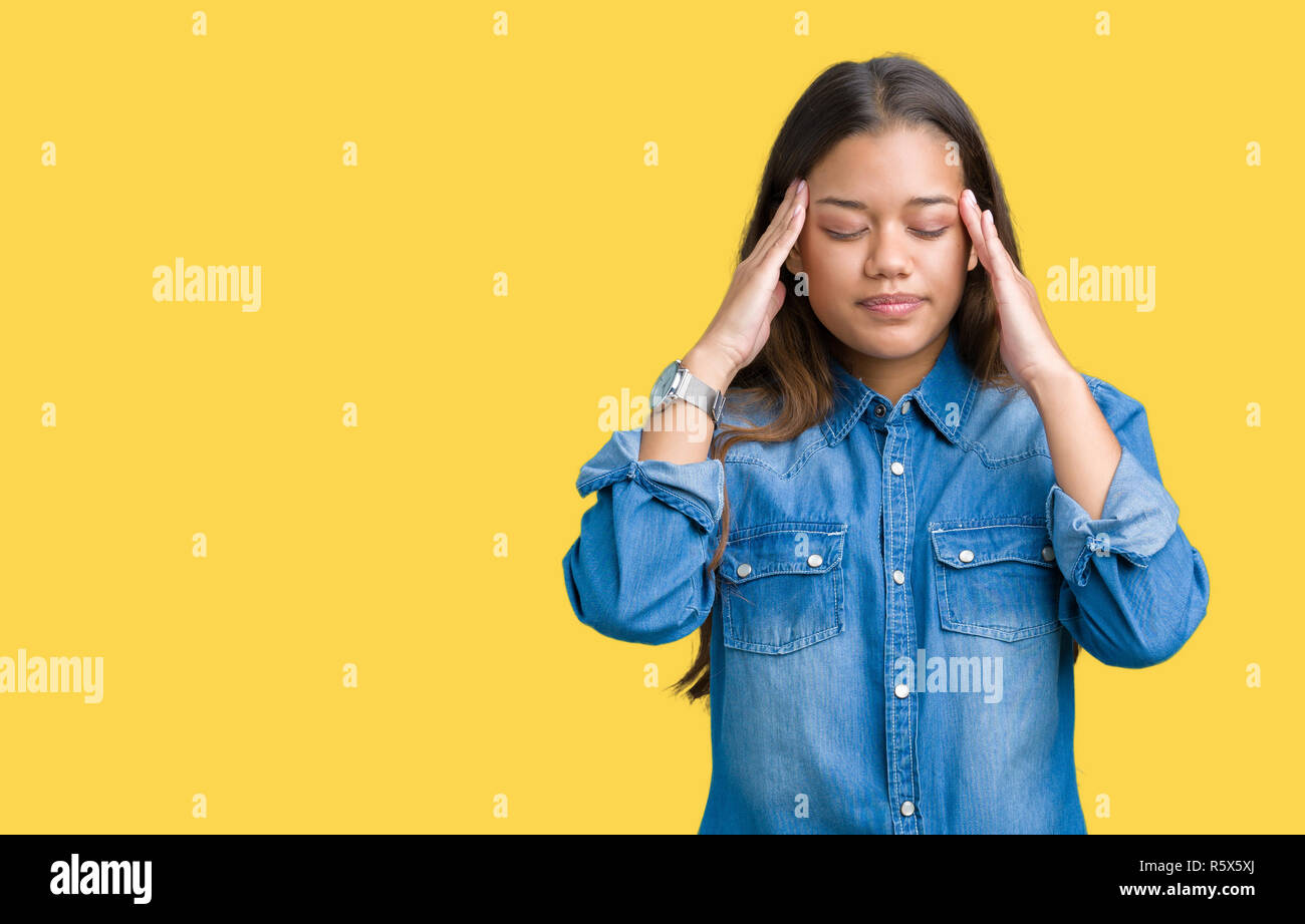Young beautiful brunette woman wearing blue denim shirt over isolated ...