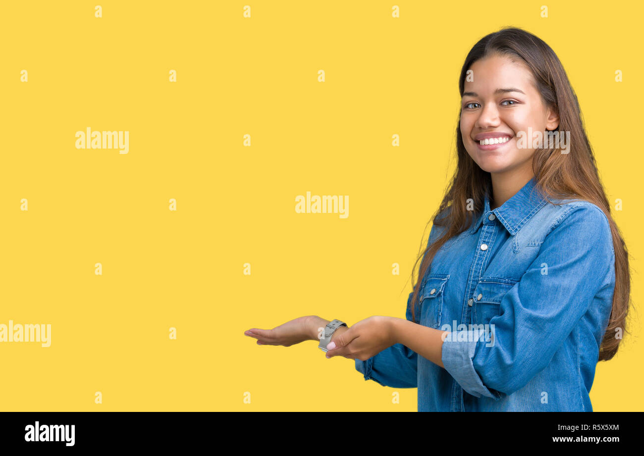 Young beautiful brunette woman wearing blue denim shirt over isolated ...