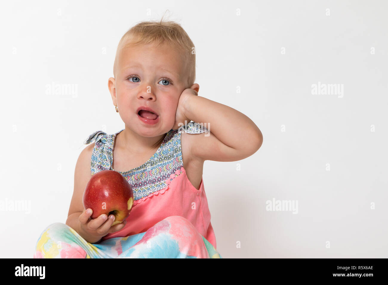 Toddler girl is touching her aching face Stock Photo - Alamy