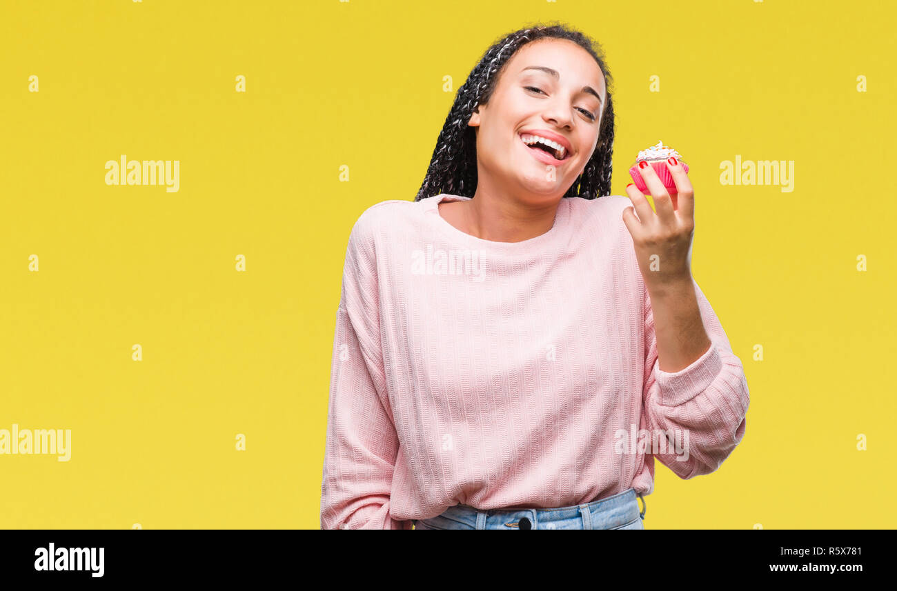 Young african american girl eating cupcake over isolated background ...