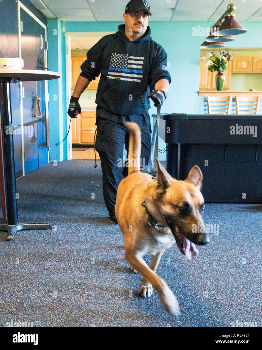 Vidal Romero with the San Joaquin County Sheriff’s Office runs his dog ...
