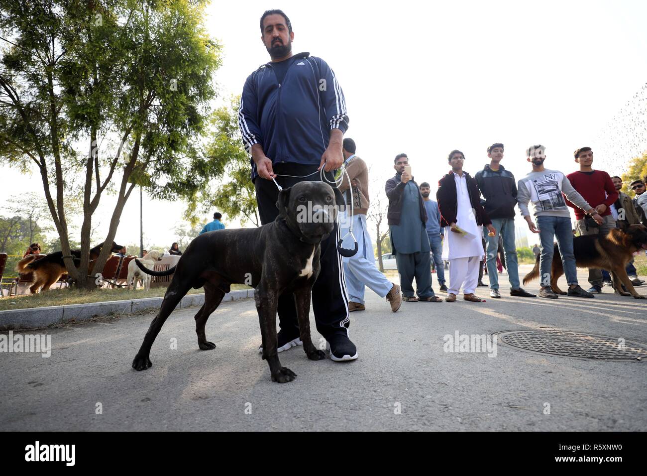 Islamabad, Pakistan. 2nd Dec, 2018. A man poses with his dog during All ...