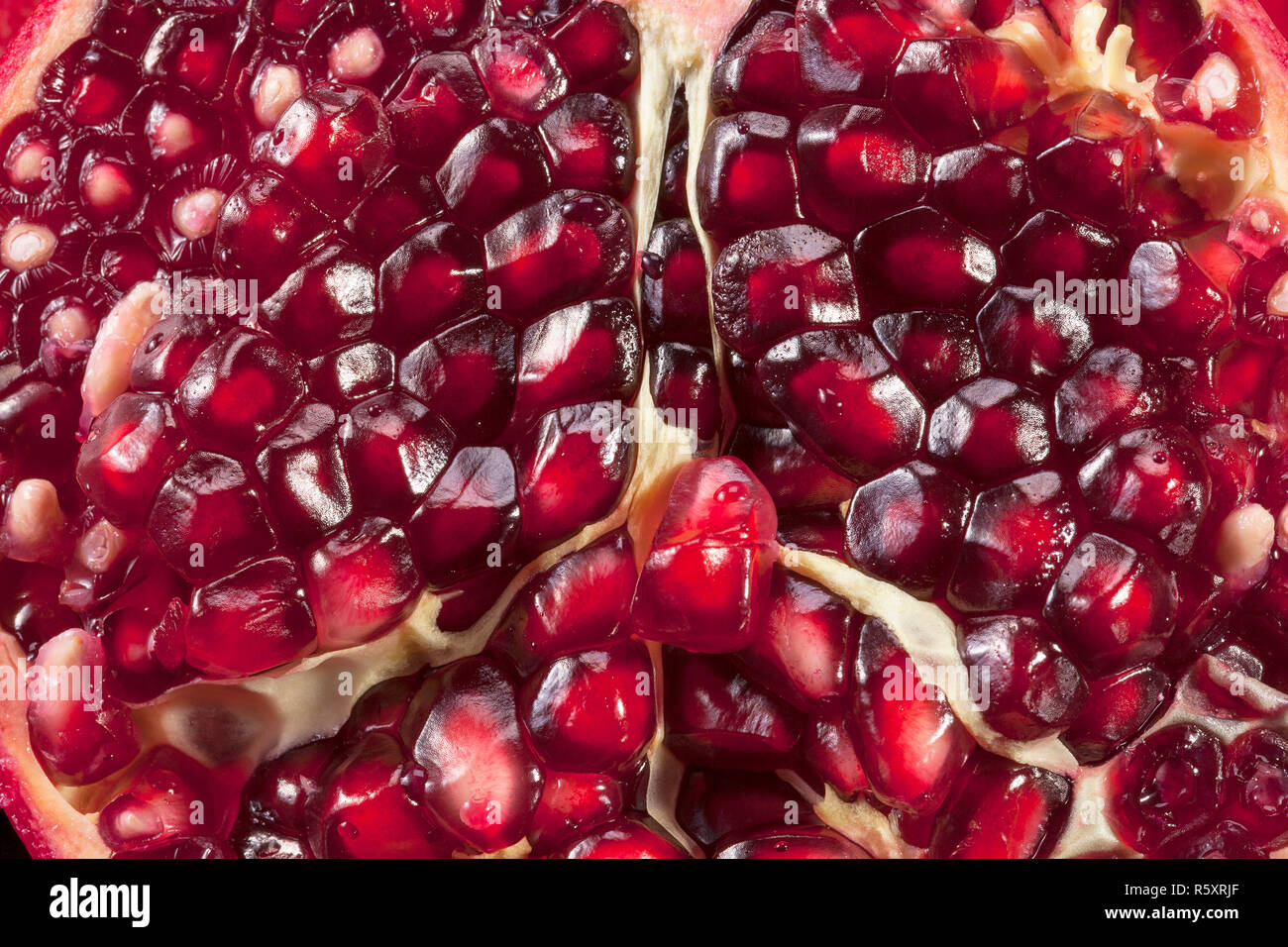 Fruit of red pomegranate, half with seeds, background, close up Stock ...