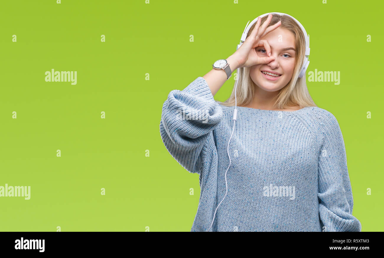 Young caucasian woman listening to music wearing headphones over ...