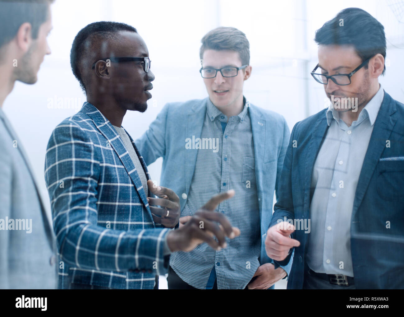 group of business people talking standing in front of a glass Board ...