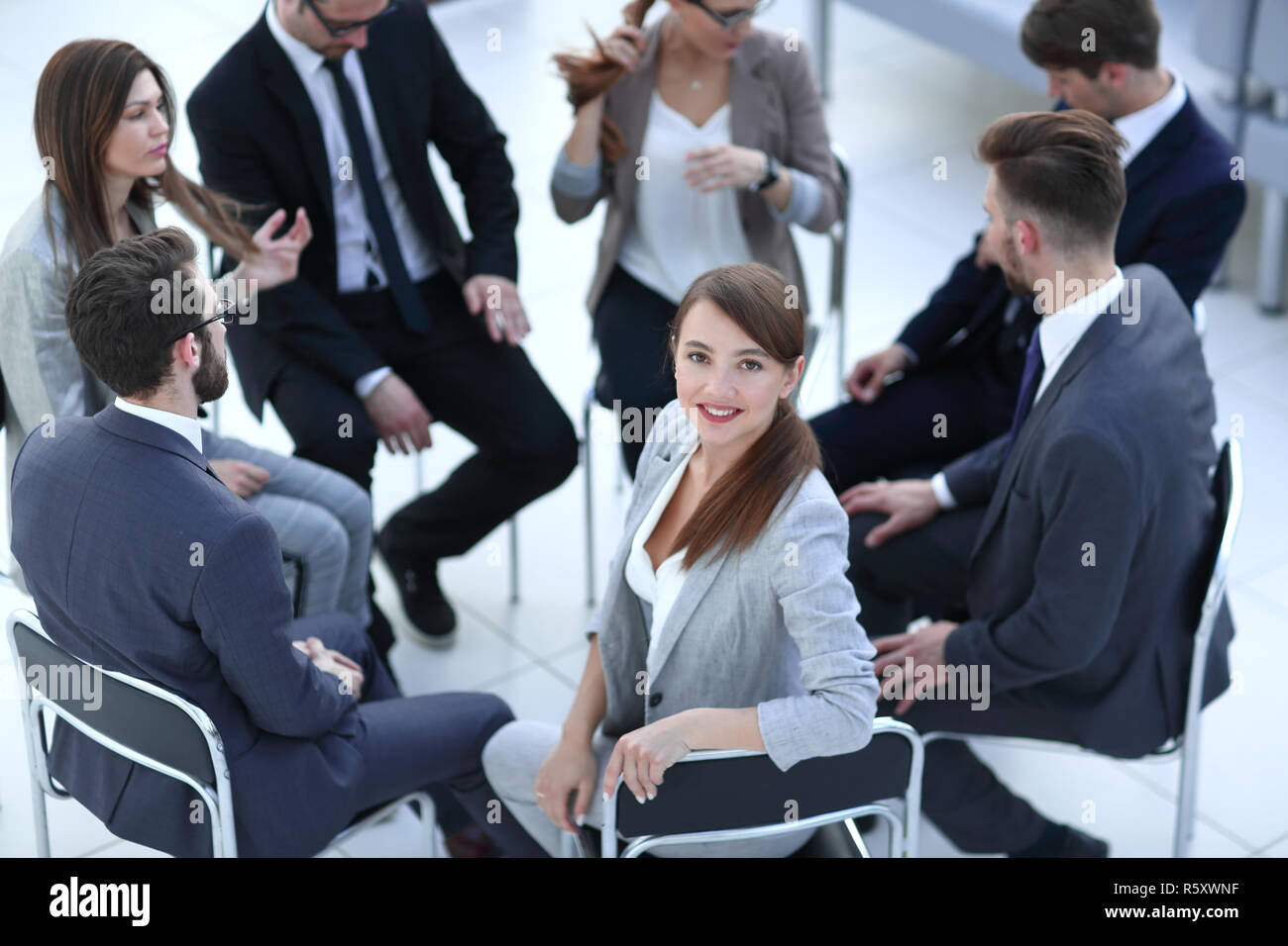 young business woman sitting in a circle of colleagues Stock Photo - Alamy