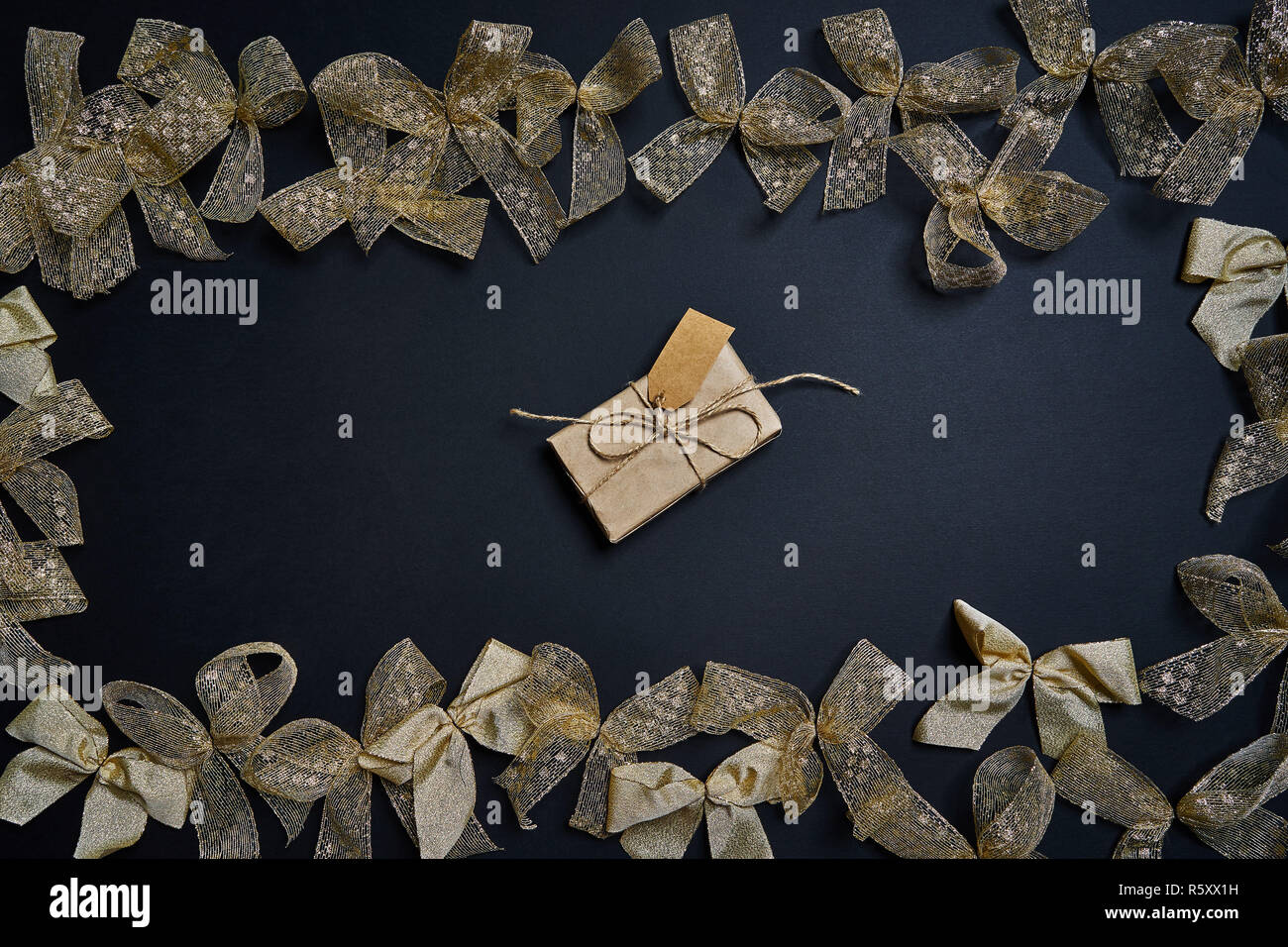 Flat lay of gift box and golden gift bows on dark background Stock ...