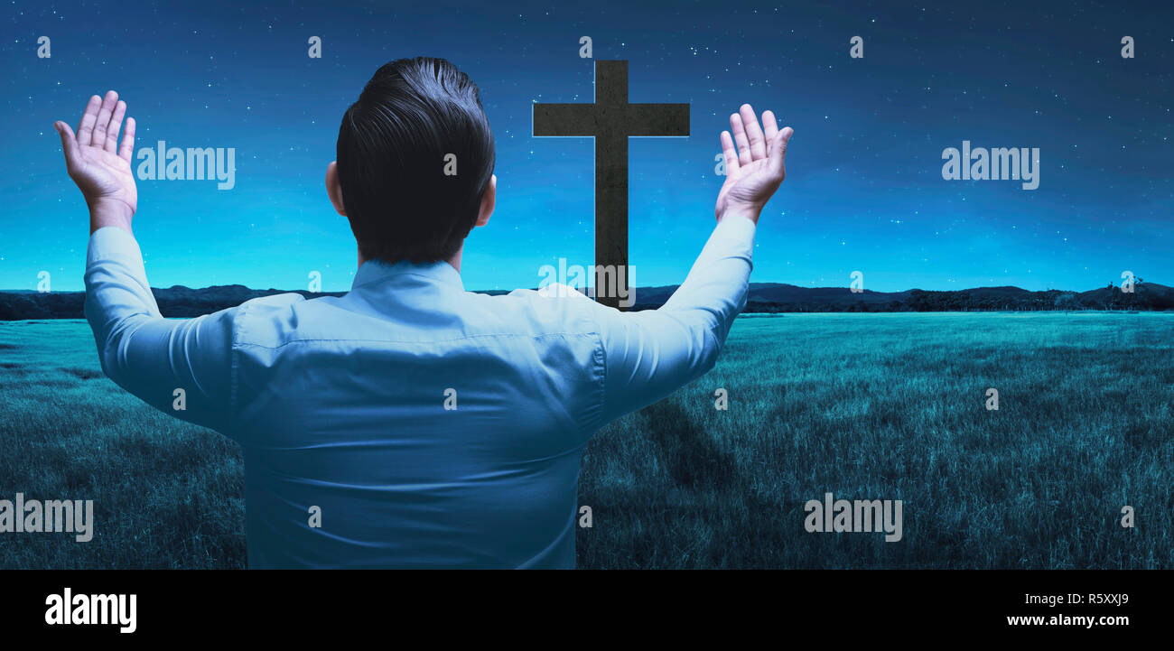 Back view of man raising hand while praying to god Stock Photo - Alamy
