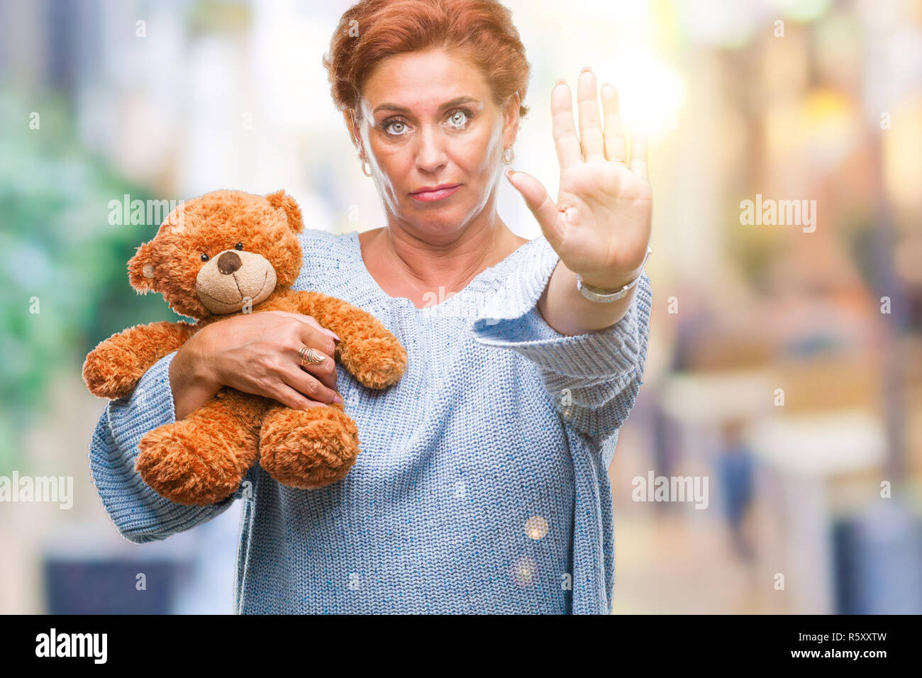 Senior caucasian woman holding teddy bear over isolated background with ...