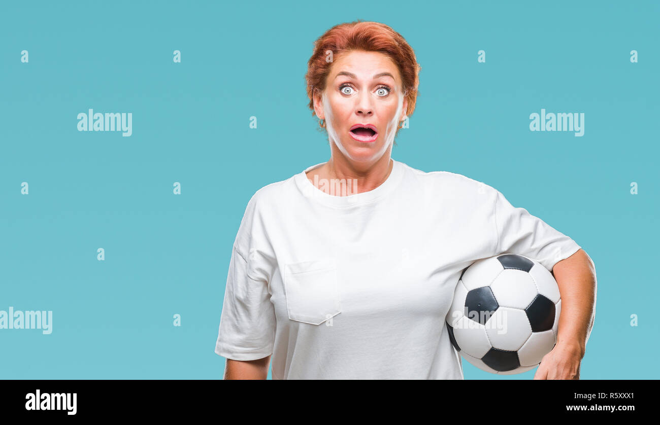 Atrractive senior caucasian redhead woman holding soccer ball over ...