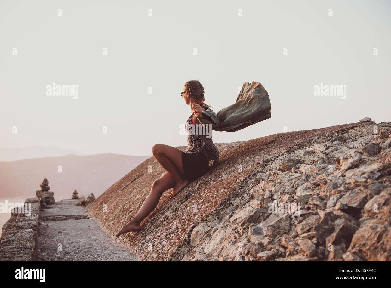 Woman sitting on stones in Monolithos castle in Rhodes, Greece Stock ...