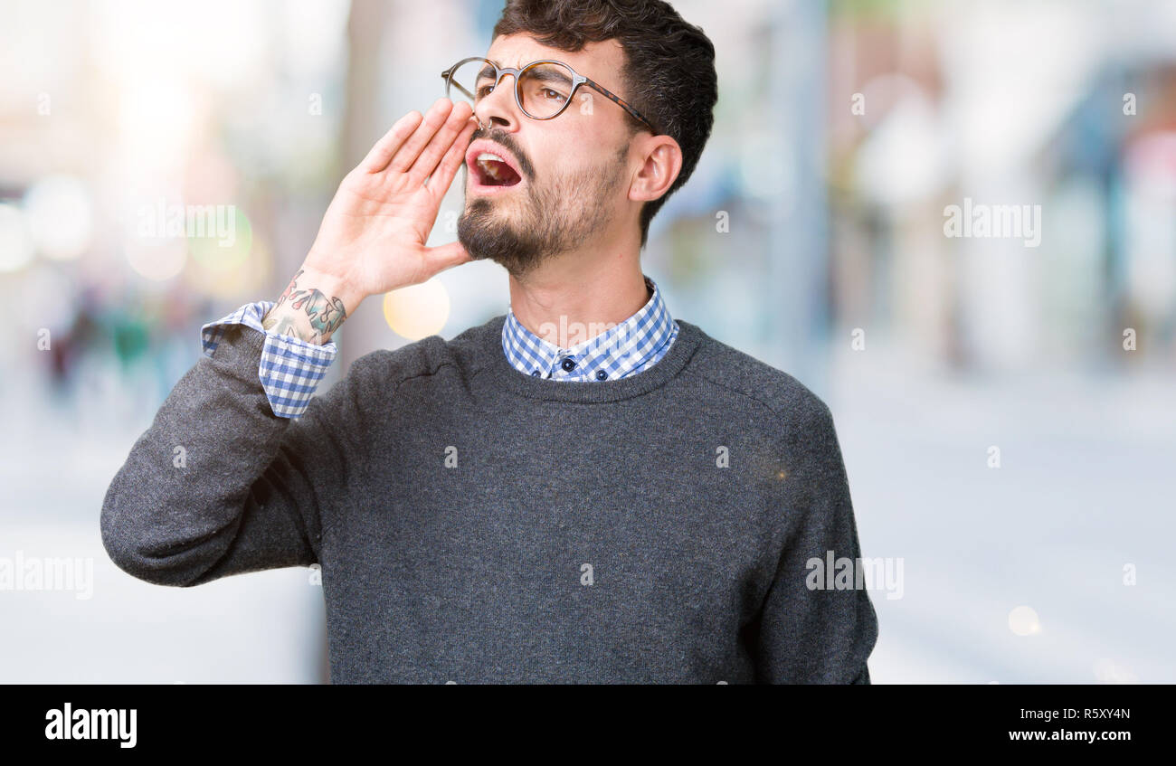 Young handsome smart man wearing glasses over isolated background ...