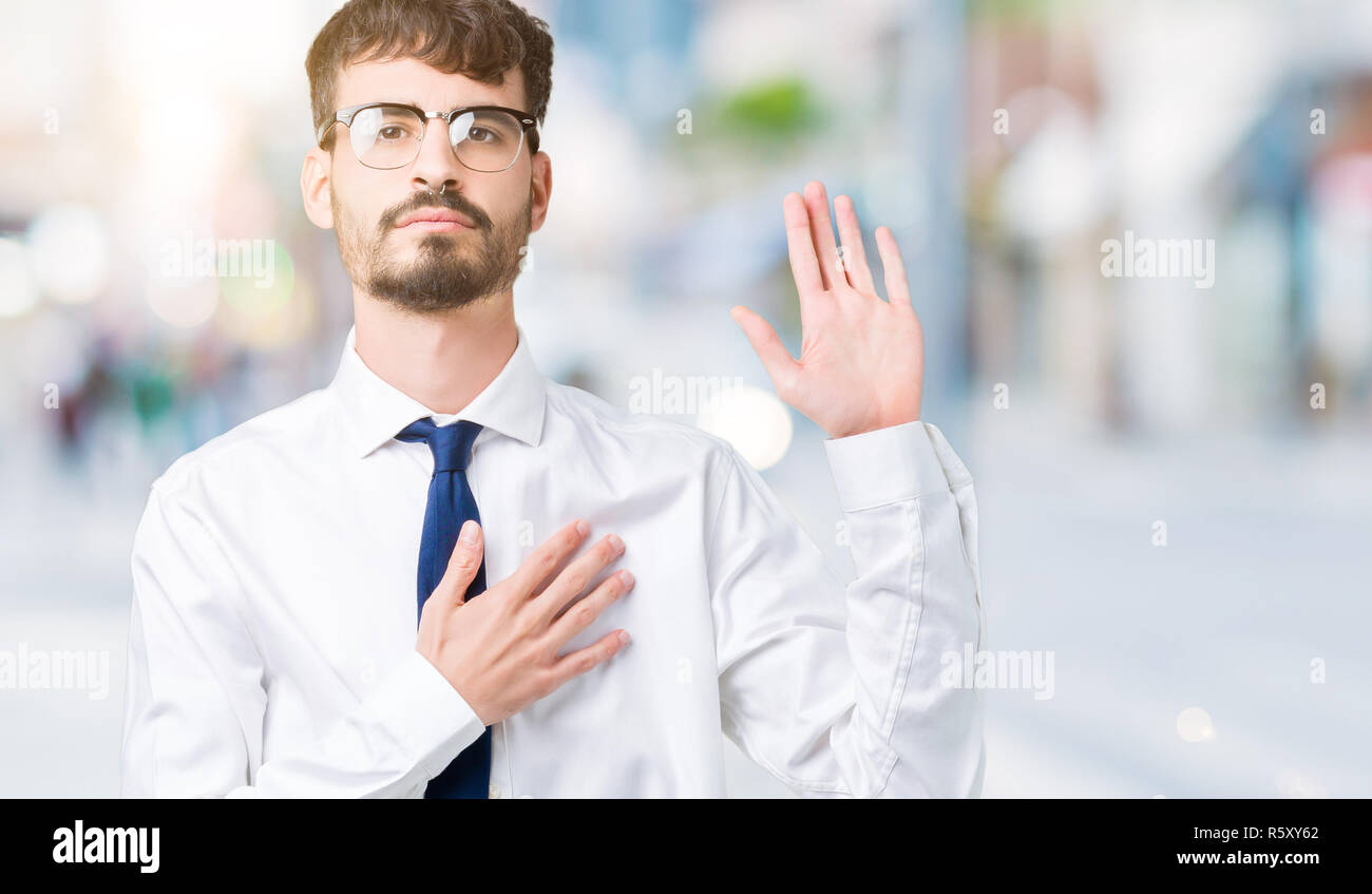 Young handsome business man wearing glasses over isolated background ...