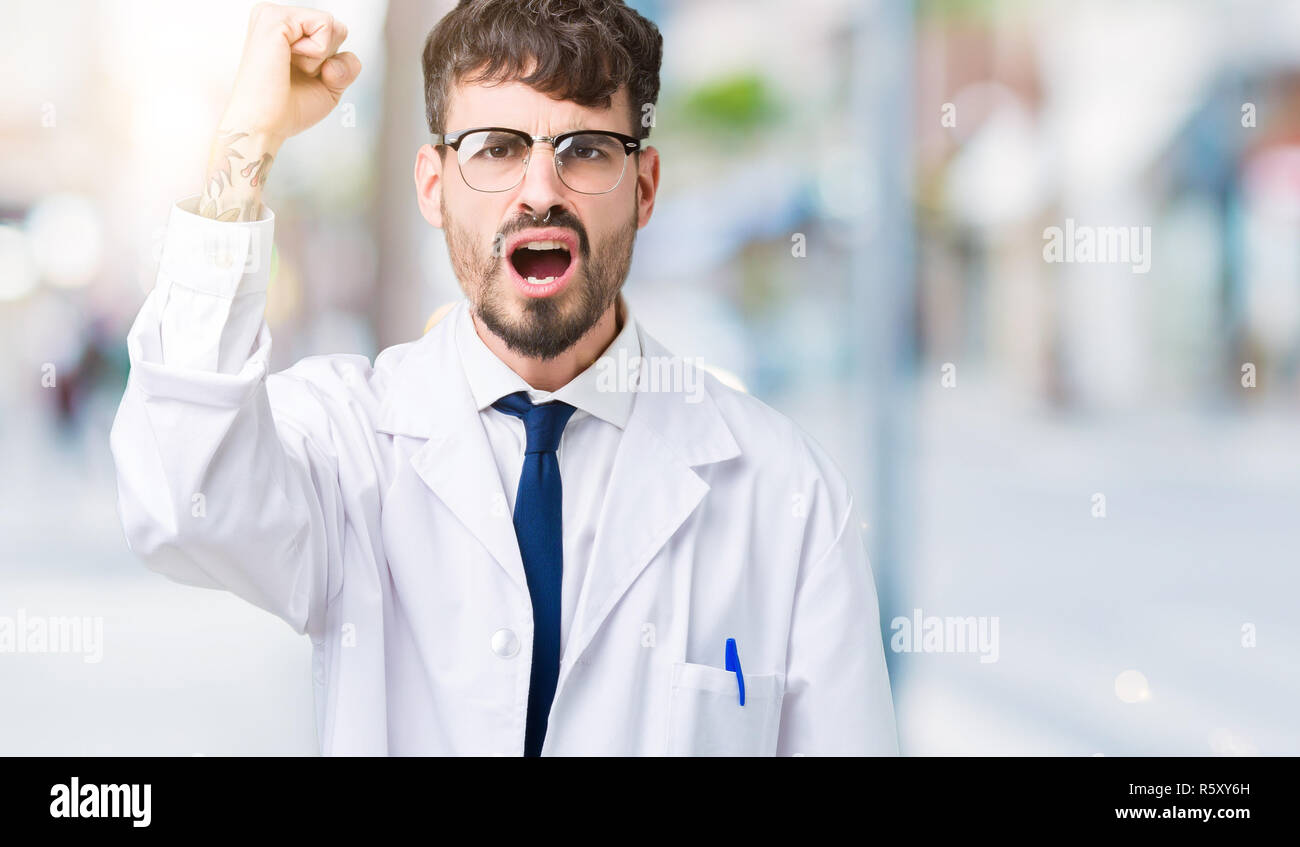 Young professional scientist man wearing white coat over isolated ...