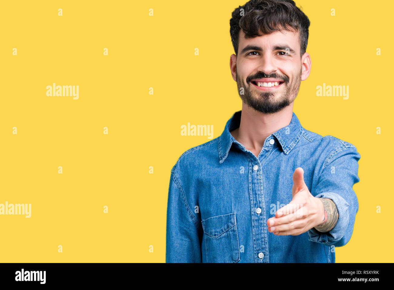 Young handsome man over isolated background smiling friendly offering ...