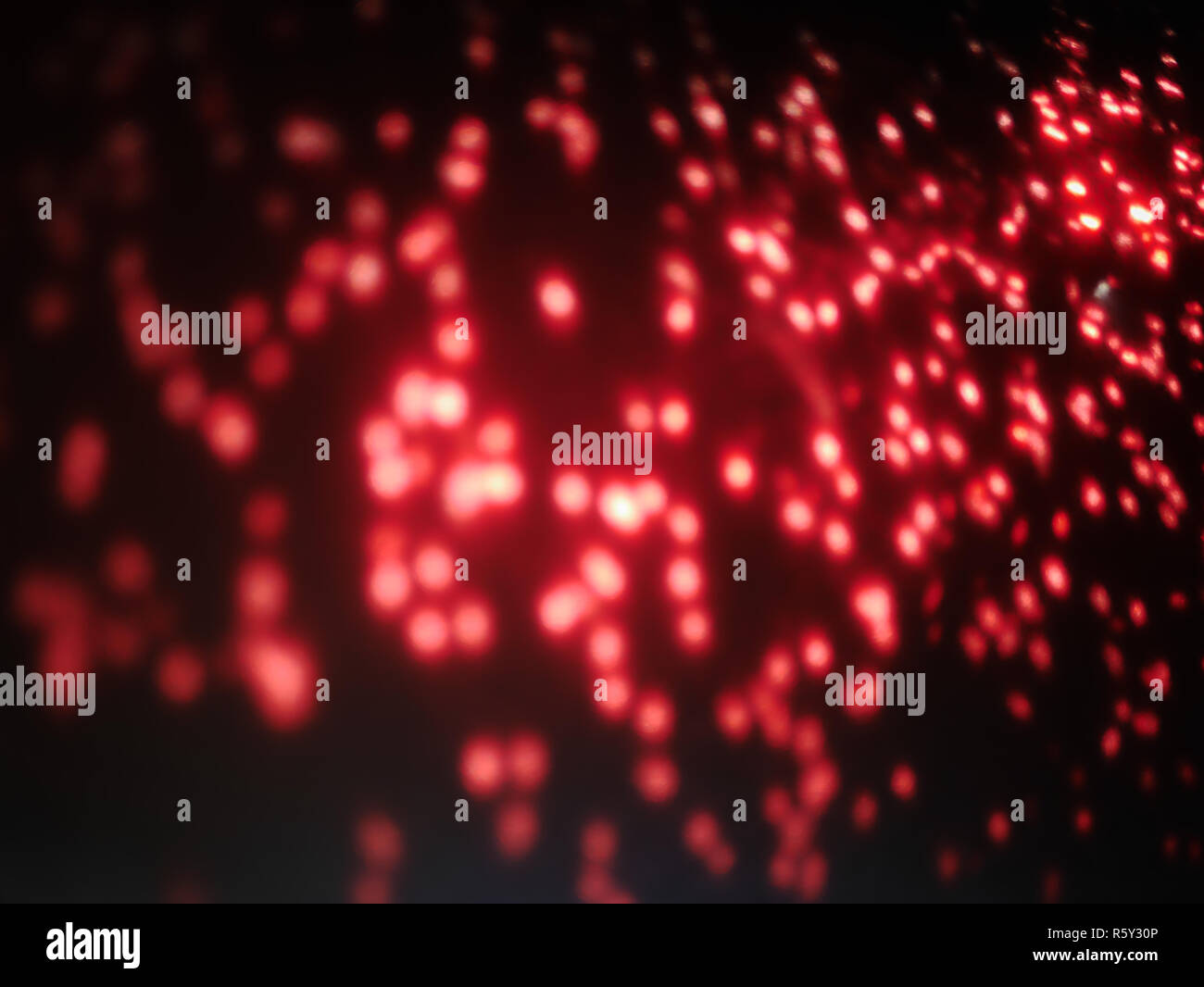 blurred red defocused bright light. lens flare. shiny spots. dark ...