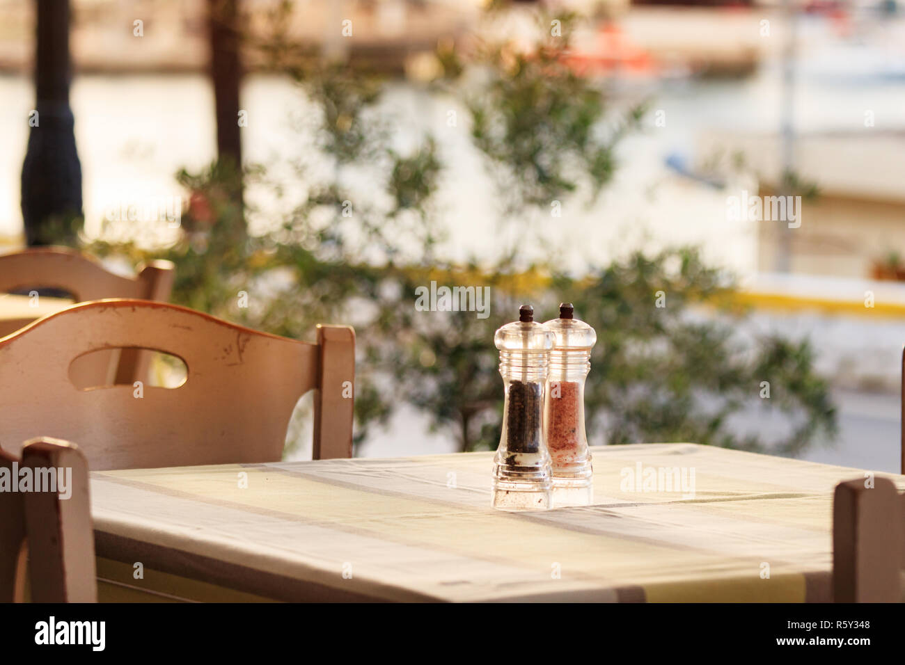 Salt and pepper grinders on a wooden table of a traditional greek ...