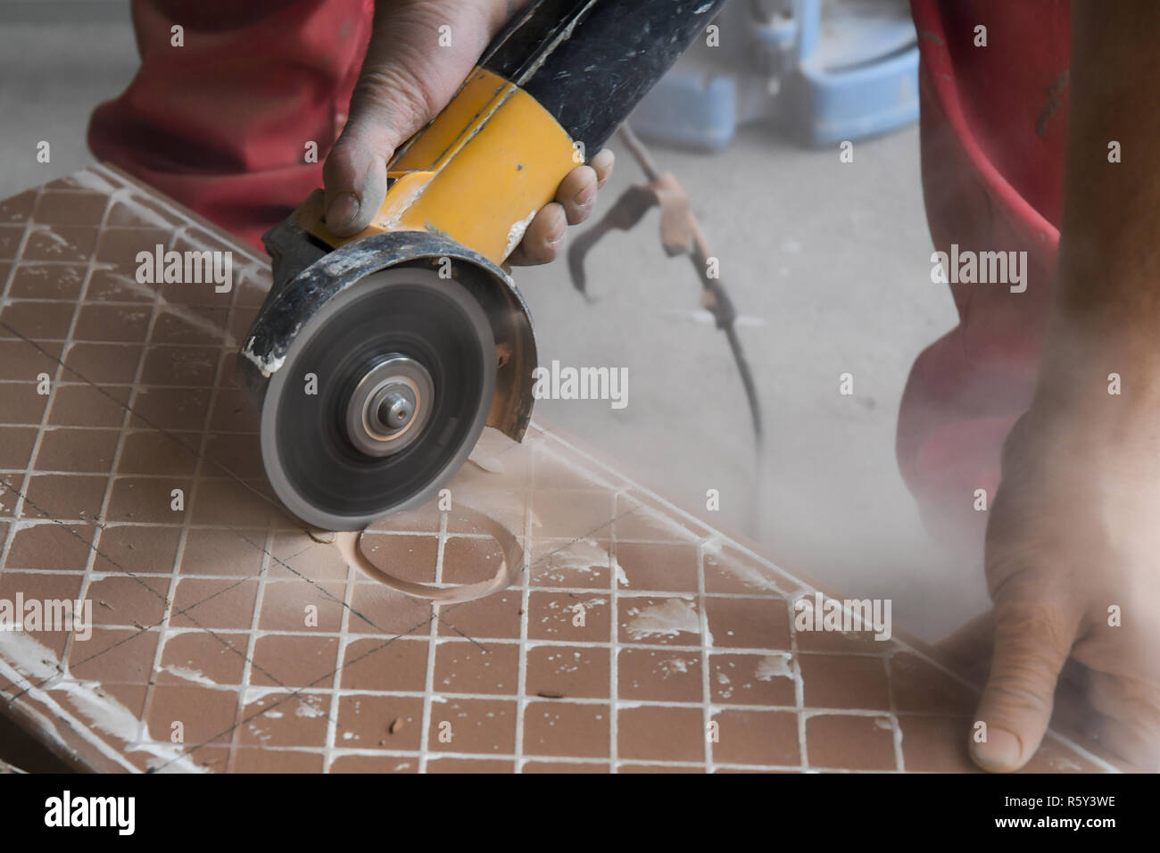 Cutting ceramic tiles. A worker places a large ceramic tile in a ...