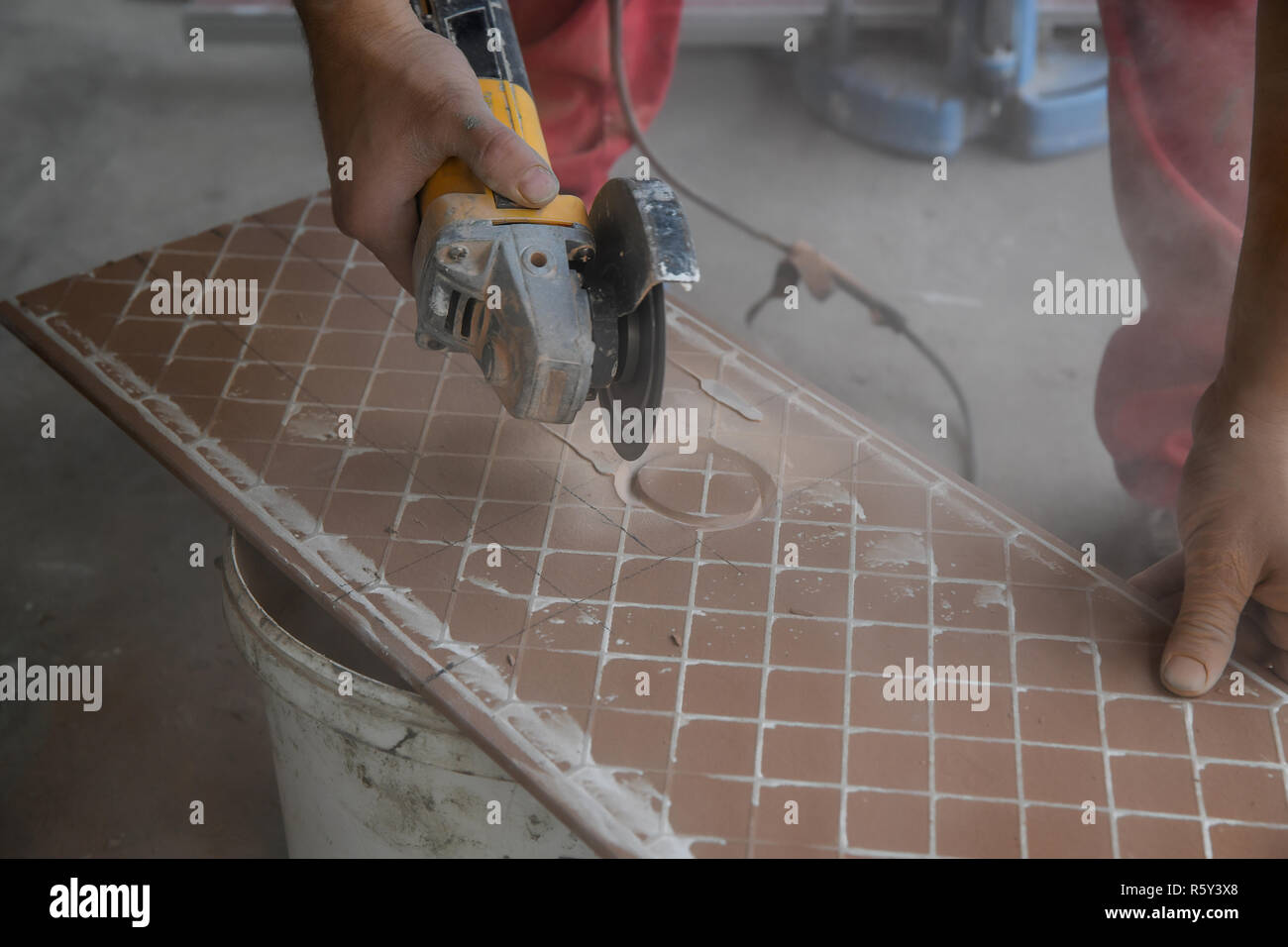 Cutting ceramic tiles. A worker places a large ceramic tile in a ...