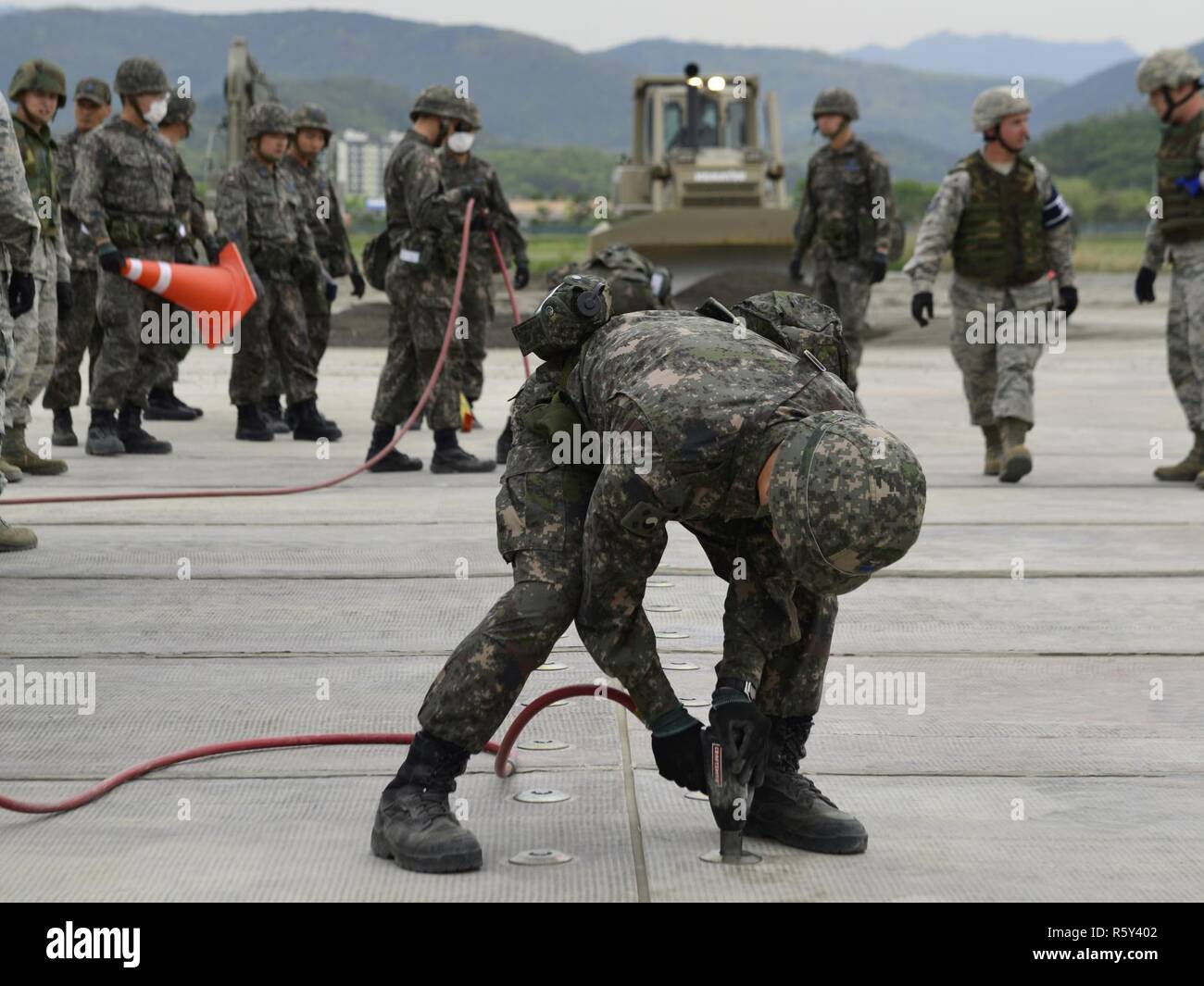 A Republic of Korea Airman secures a rapid-runway repair fiberglass mat ...