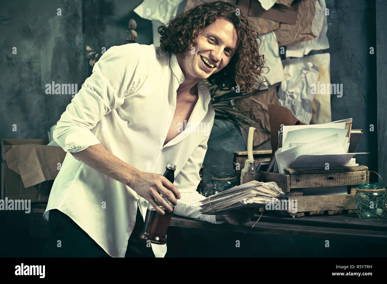 Writer at work. Handsome young writer standing near the table and ...