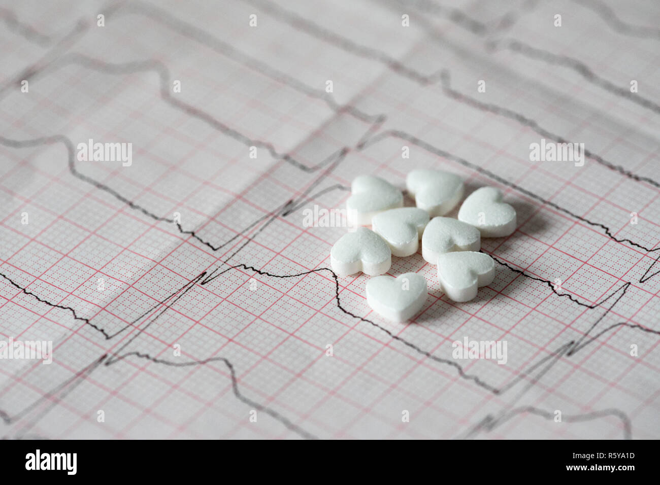 Cardiology. Macro of ECG graph and cardio pills. Pills as a heart Stock ...