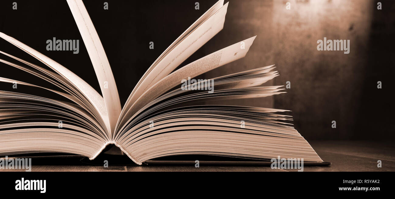 Composition with open book on the table Stock Photo - Alamy