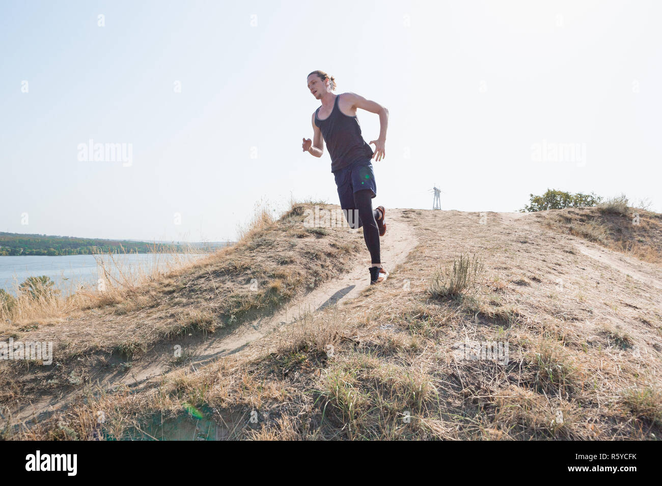 Running sport. Man runner sprinting outdoor in scenic nature. Fit ...