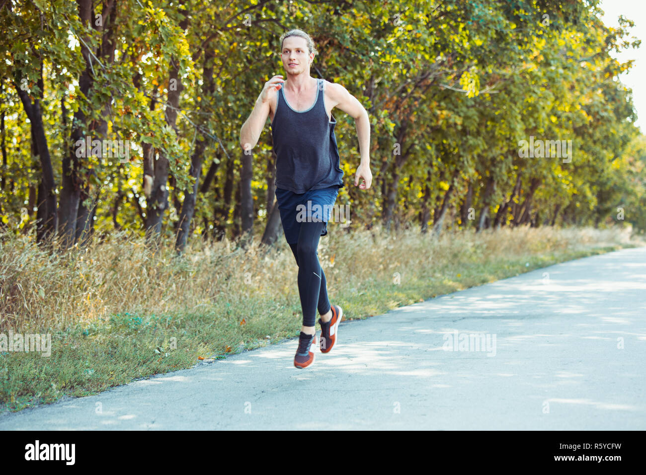 Running sport. Man runner sprinting outdoor in scenic nature. Fit ...