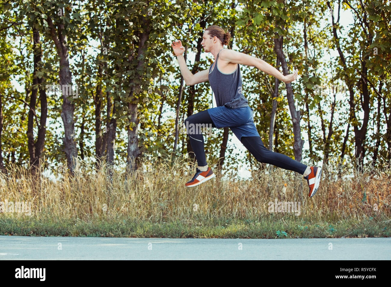 Running sport. Man runner sprinting outdoor in scenic nature. Fit ...