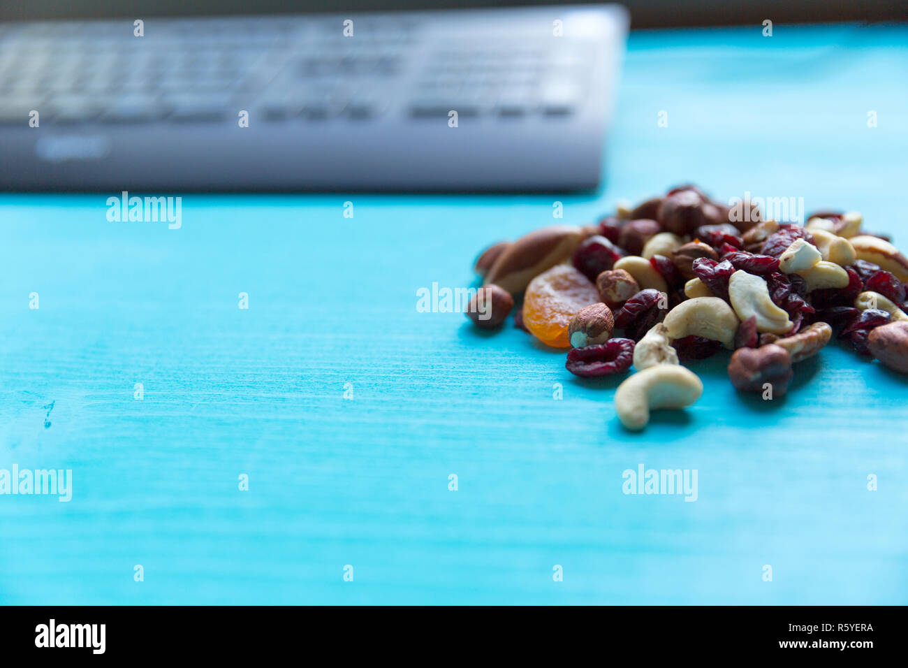Healthy quick snack in office. Dry fruits and nuts on desk with ...