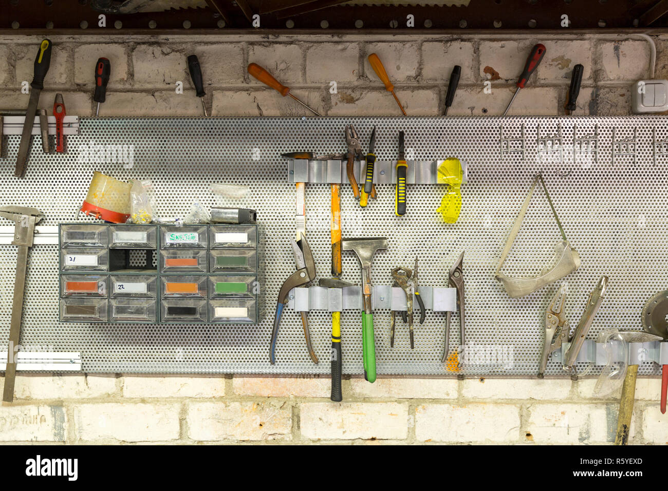 Old tools hanging on wall in metalwork workshop , Tool shelf against a ...